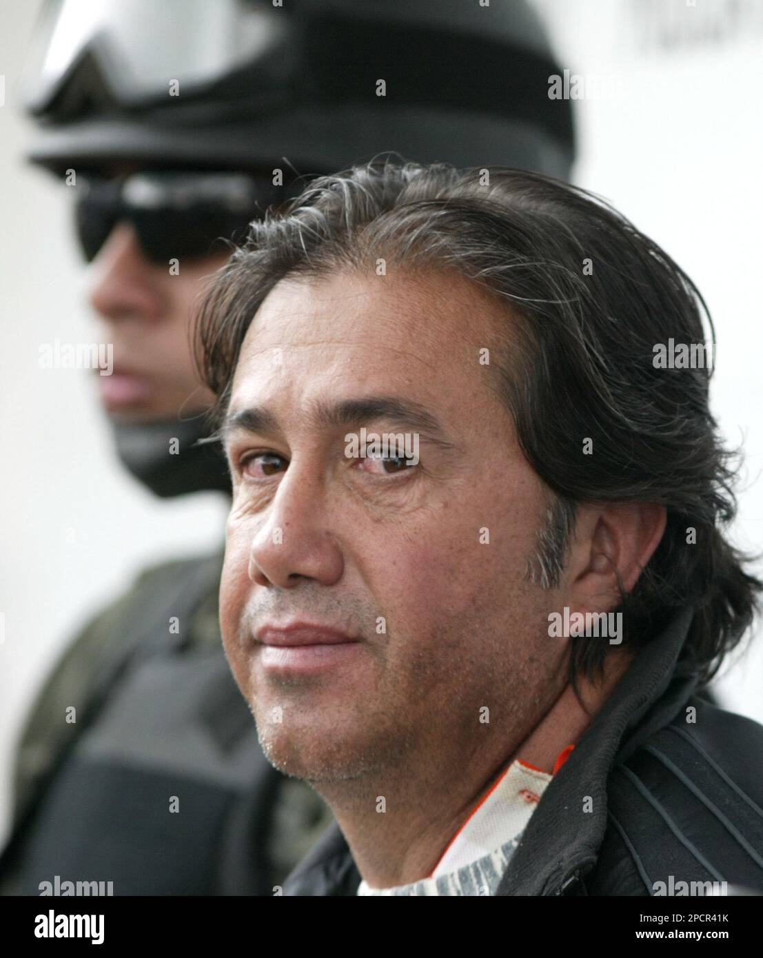 Police officer escort Eduardo Restrepo Victoria at the National Police ...