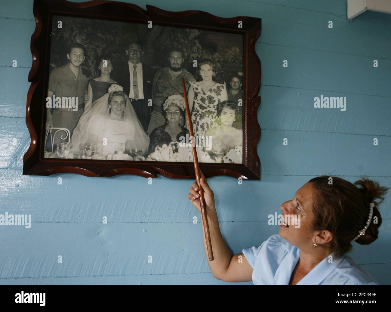 A tour guide points to an old picture of Cuba's President Fidel Castro ...