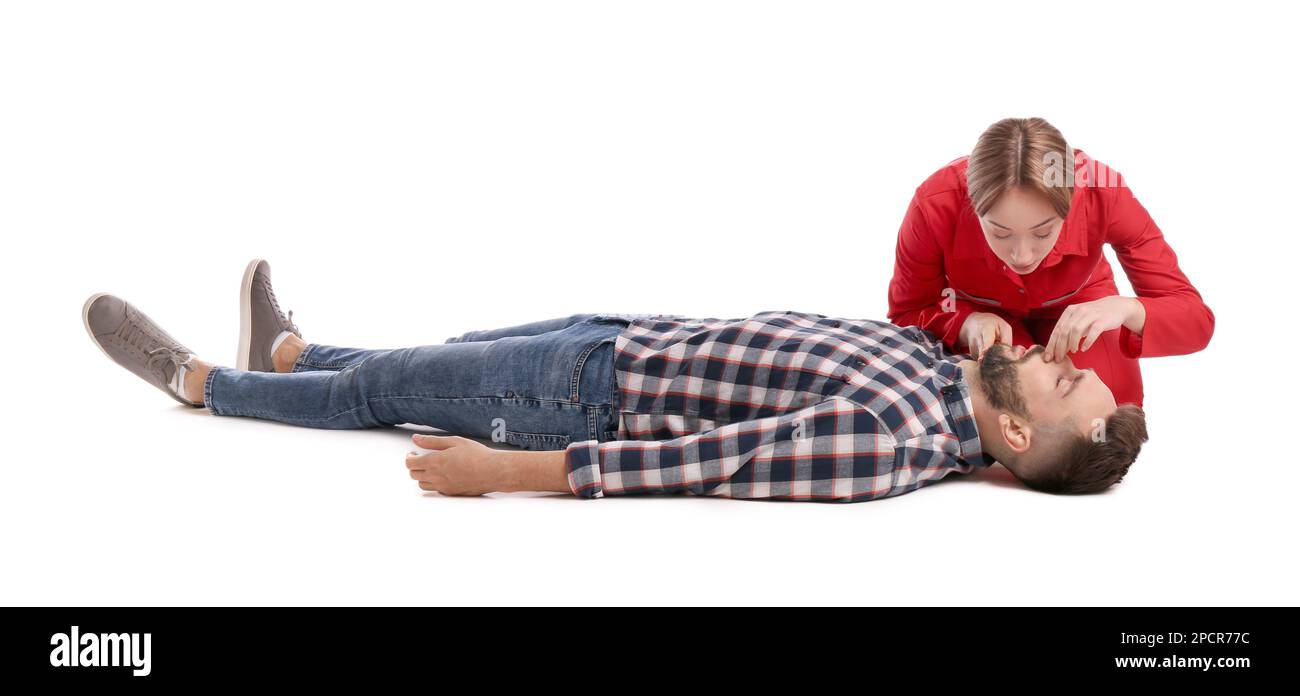 Paramedic in uniform performing first aid on unconscious man against ...