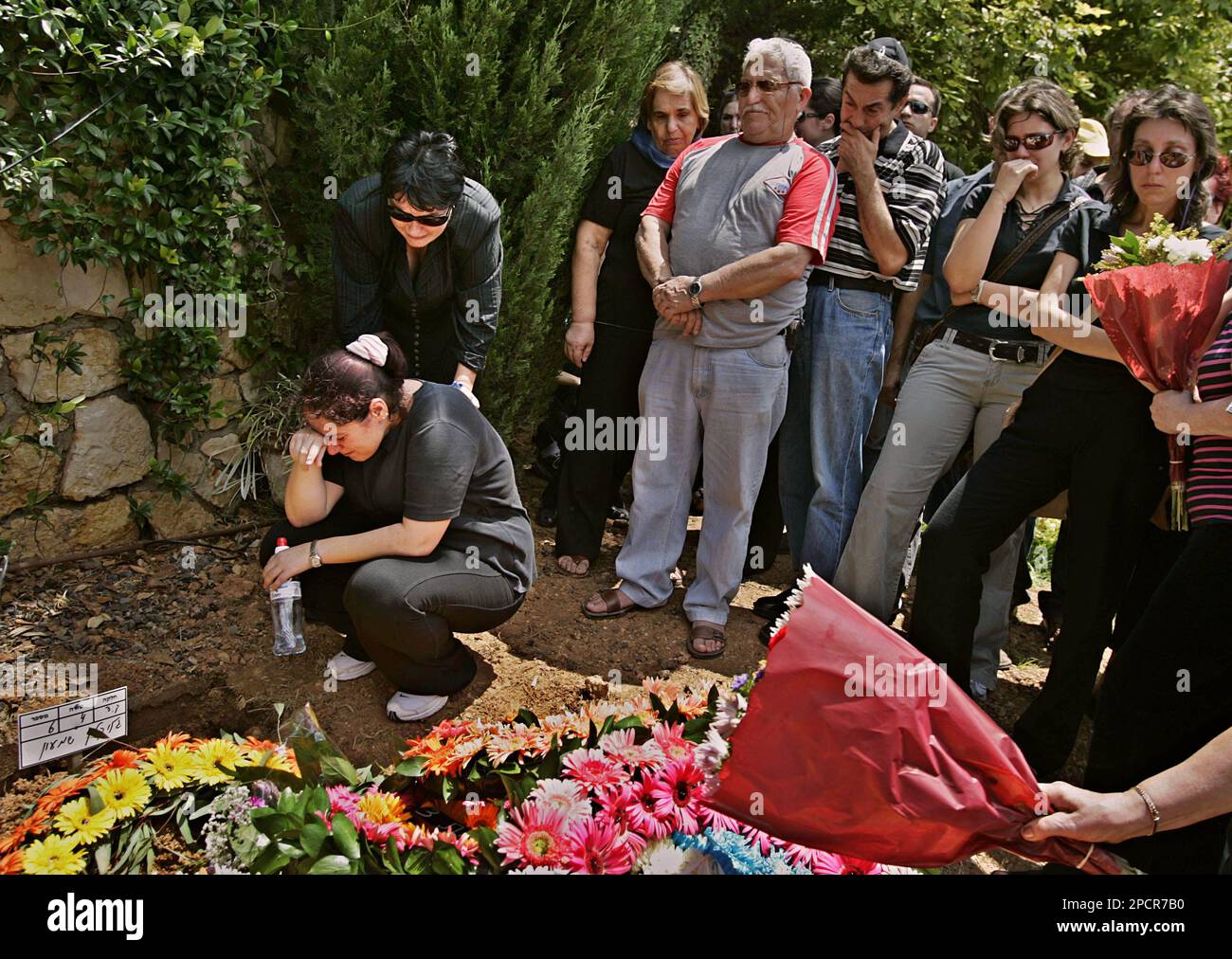 Relatives and friends cry next to the grave of Shimon Gliklich, who was ...