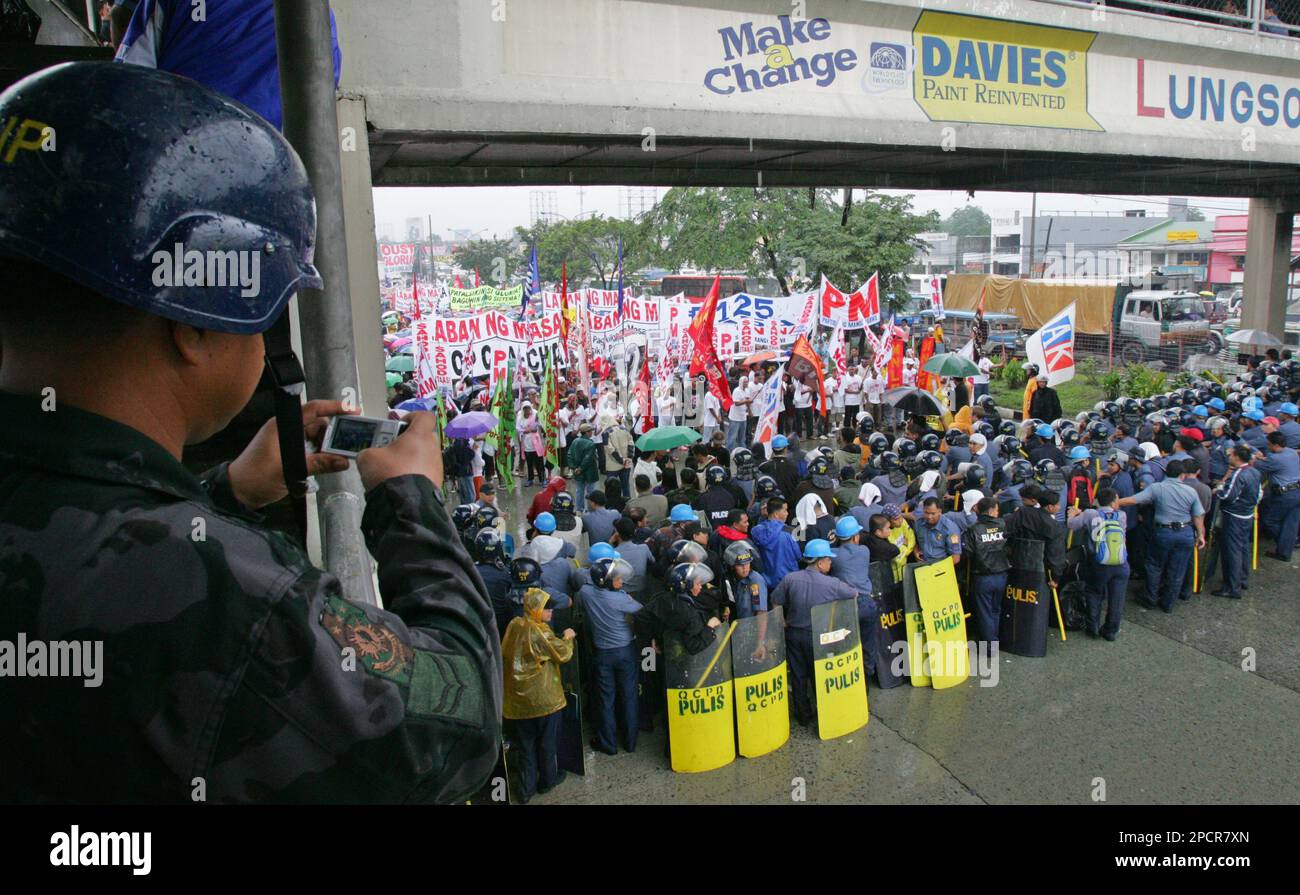 A riot police takes pictures of protesters as they are blocked from ...