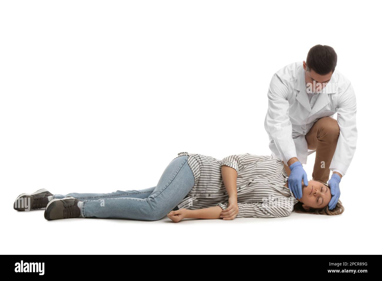 Doctor in uniform practicing first aid on woman against white ...