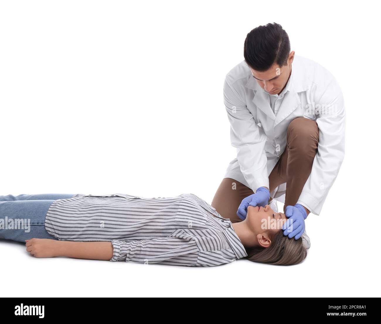 Doctor in uniform practicing first aid on woman against white ...