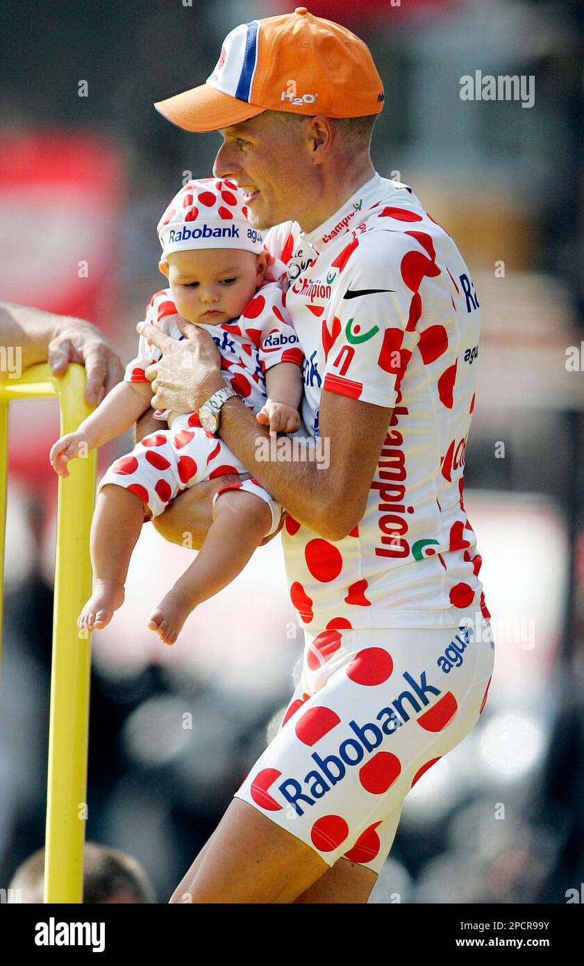 Michael Rasmussen of Denmark holds his son as he gets to the podium ...