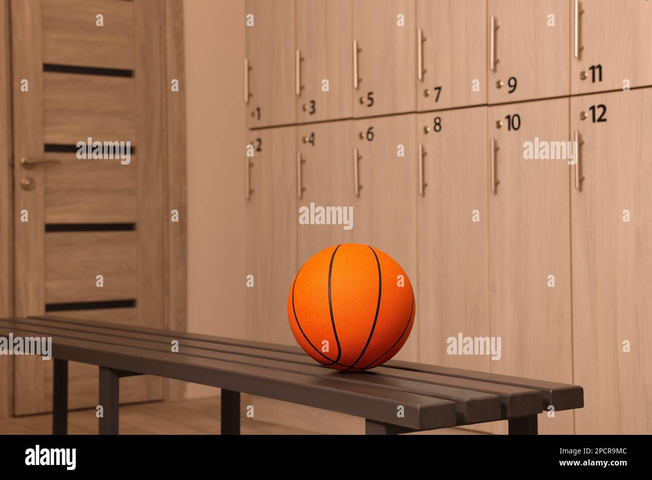 Orange basketball ball on wooden bench in locker room Stock Photo - Alamy