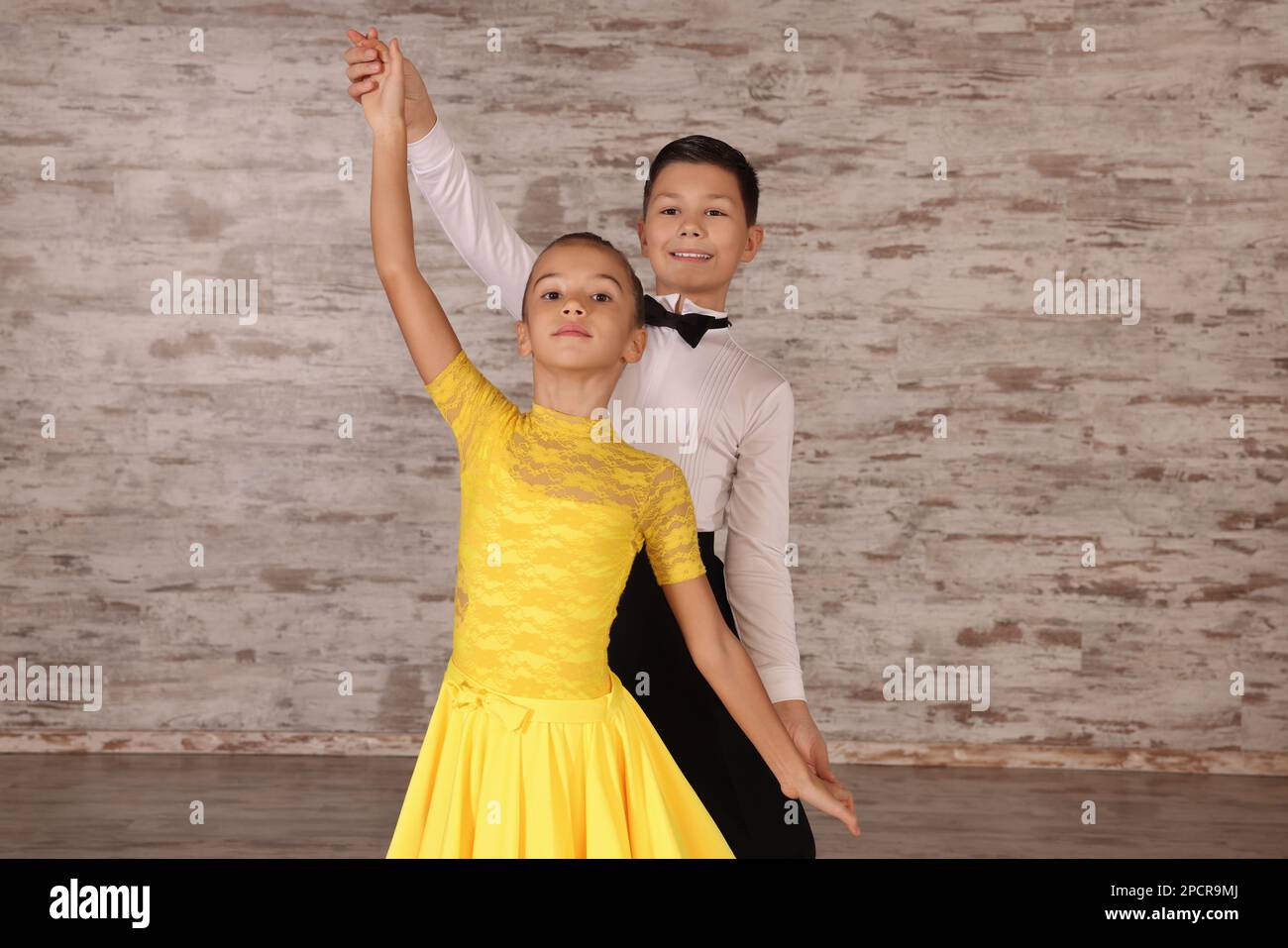 Beautifully dressed couple of kids dancing together in studio Stock ...