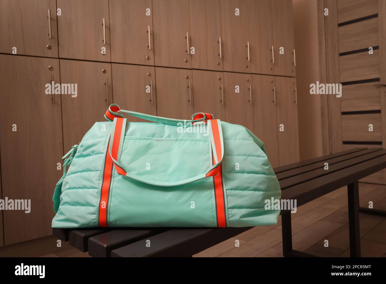 Sports bag on wooden bench in locker room Stock Photo - Alamy