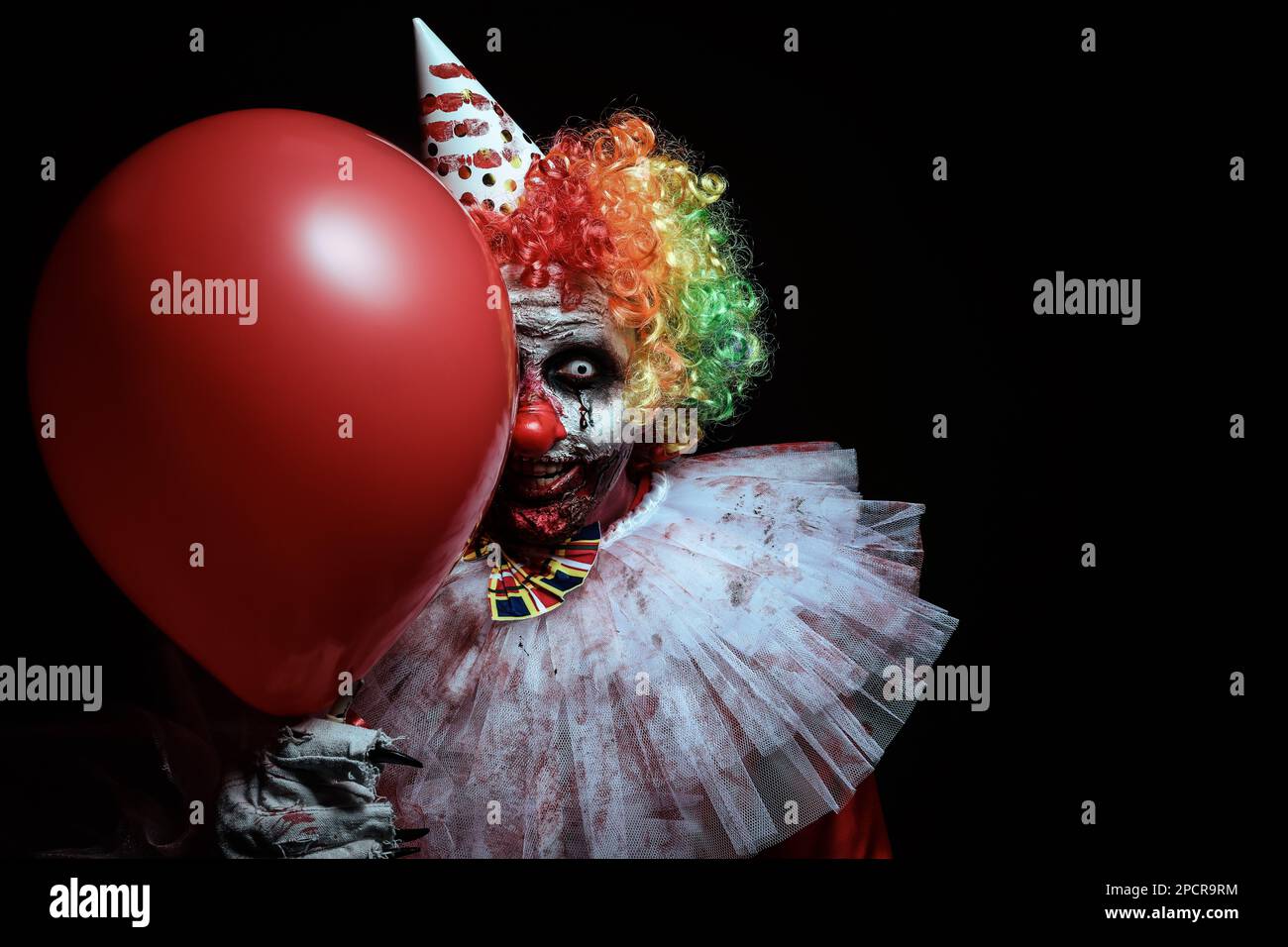 Terrifying clown with red air balloon on black background. Halloween ...