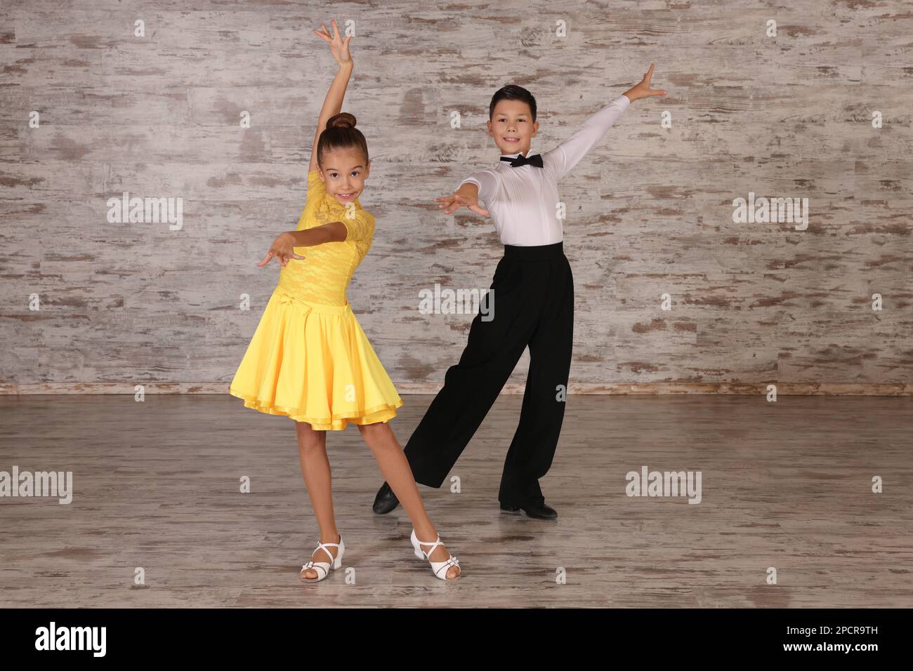 Beautifully dressed couple of kids dancing together in studio Stock ...
