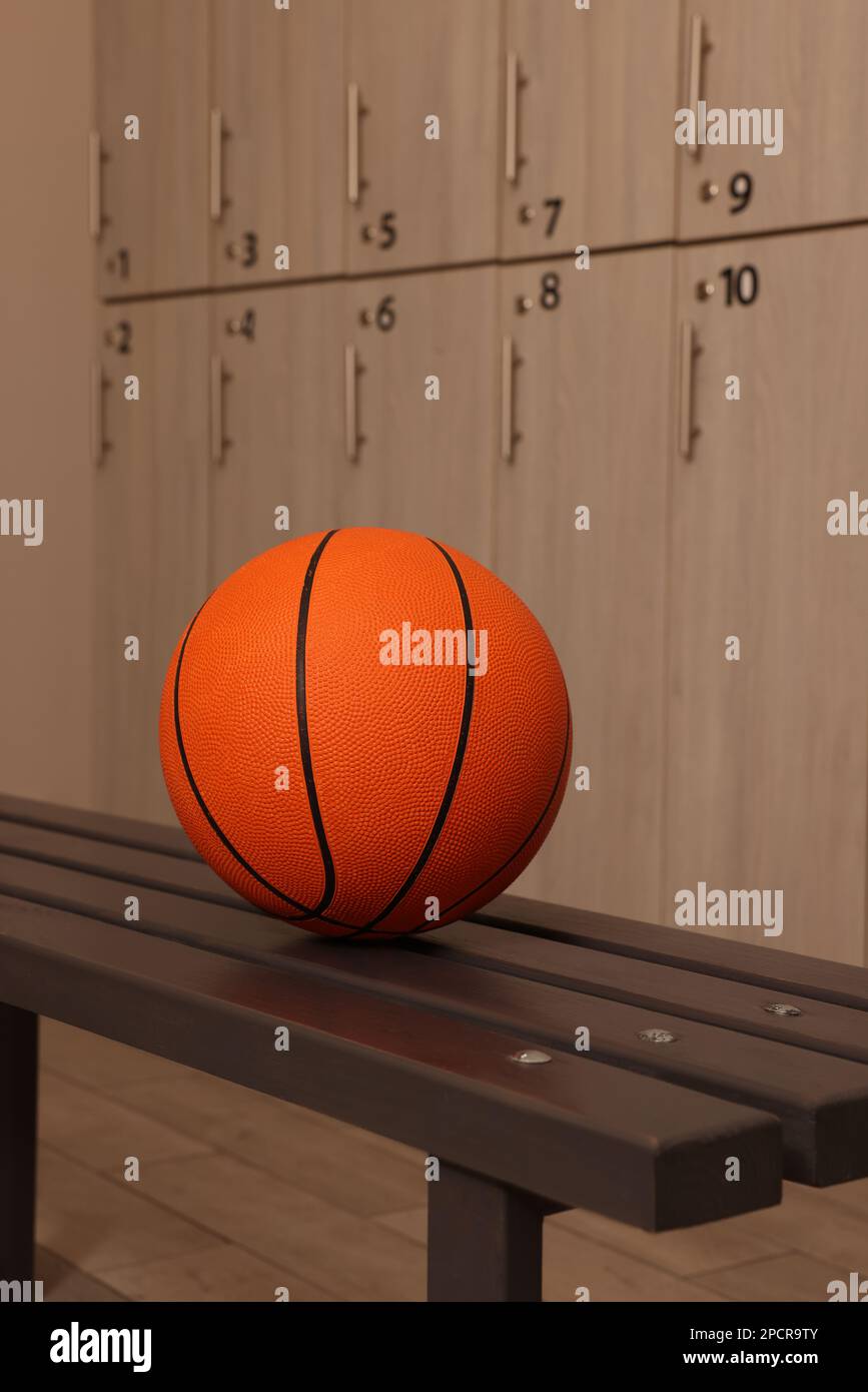 Orange basketball ball on wooden bench in locker room Stock Photo - Alamy