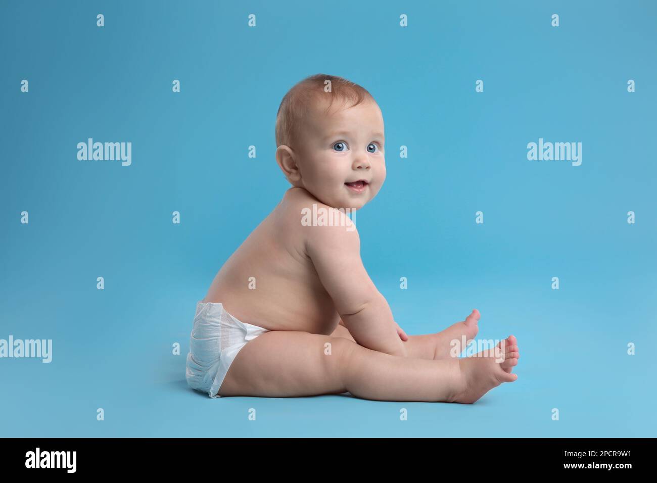 Cute baby in dry soft diaper sitting on light blue background Stock ...