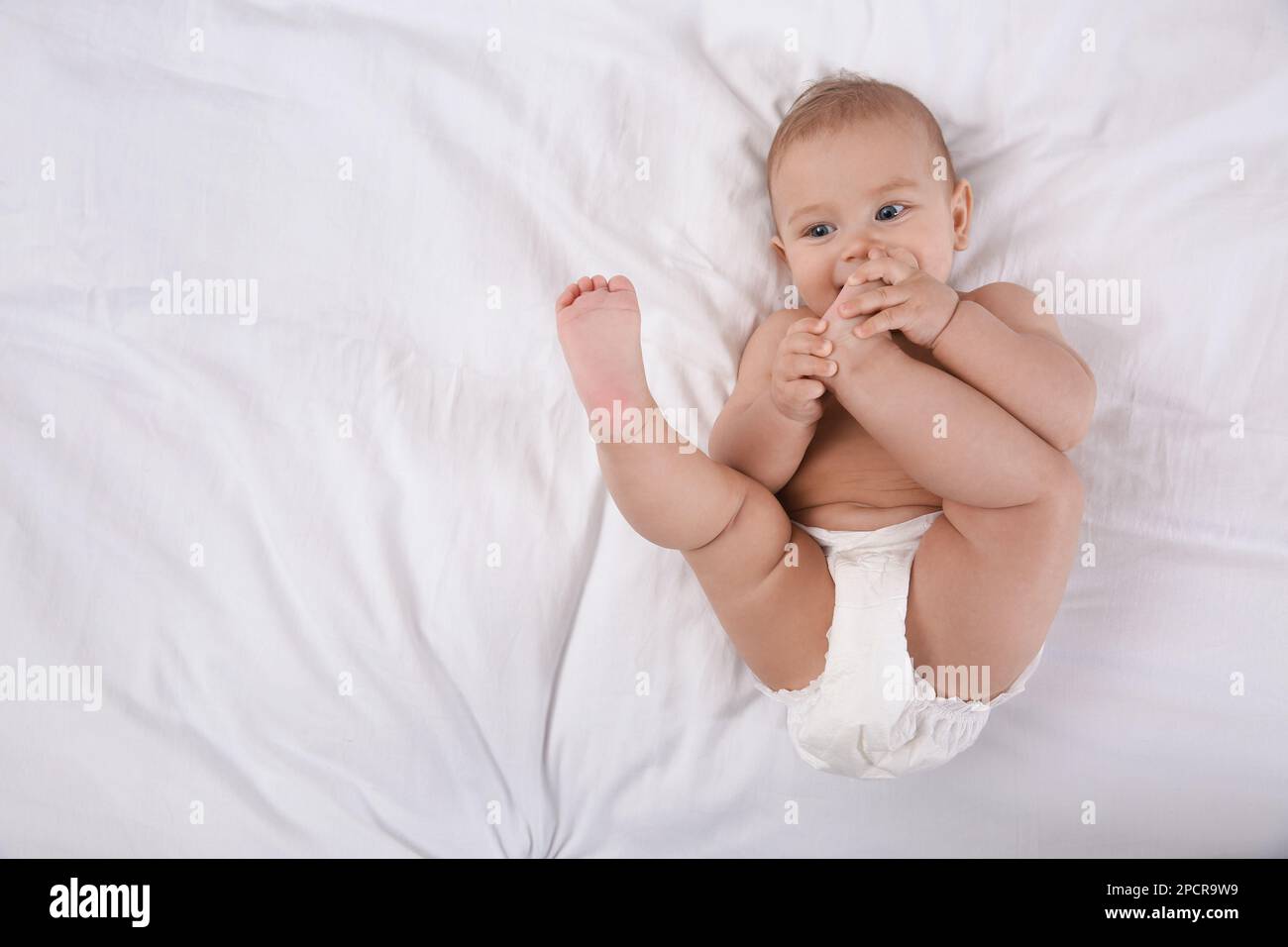 Cute baby in dry soft diaper on white bed, top view. space for text Stock Photo - Alamy