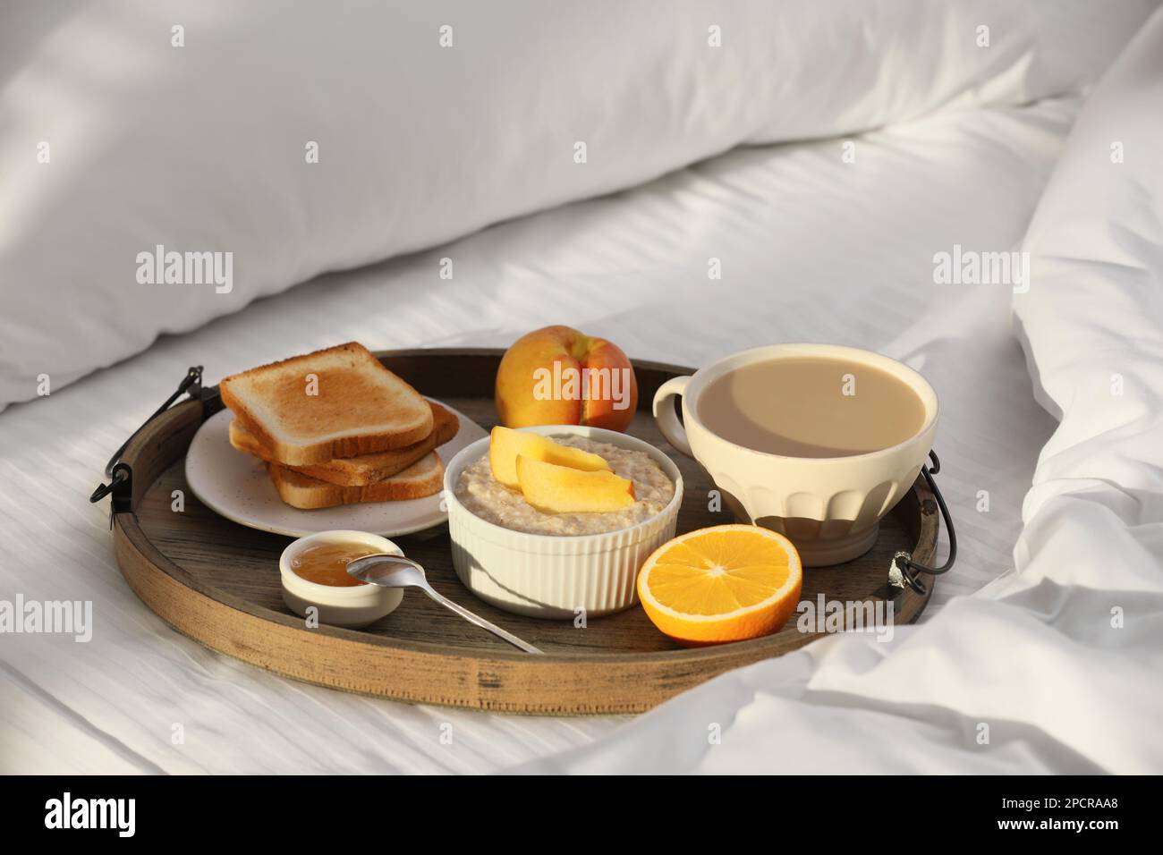 Wooden tray with delicious breakfast on bed in morning Stock Photo - Alamy