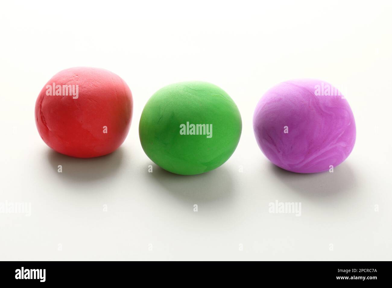 Different color play dough balls on white background Stock Photo - Alamy