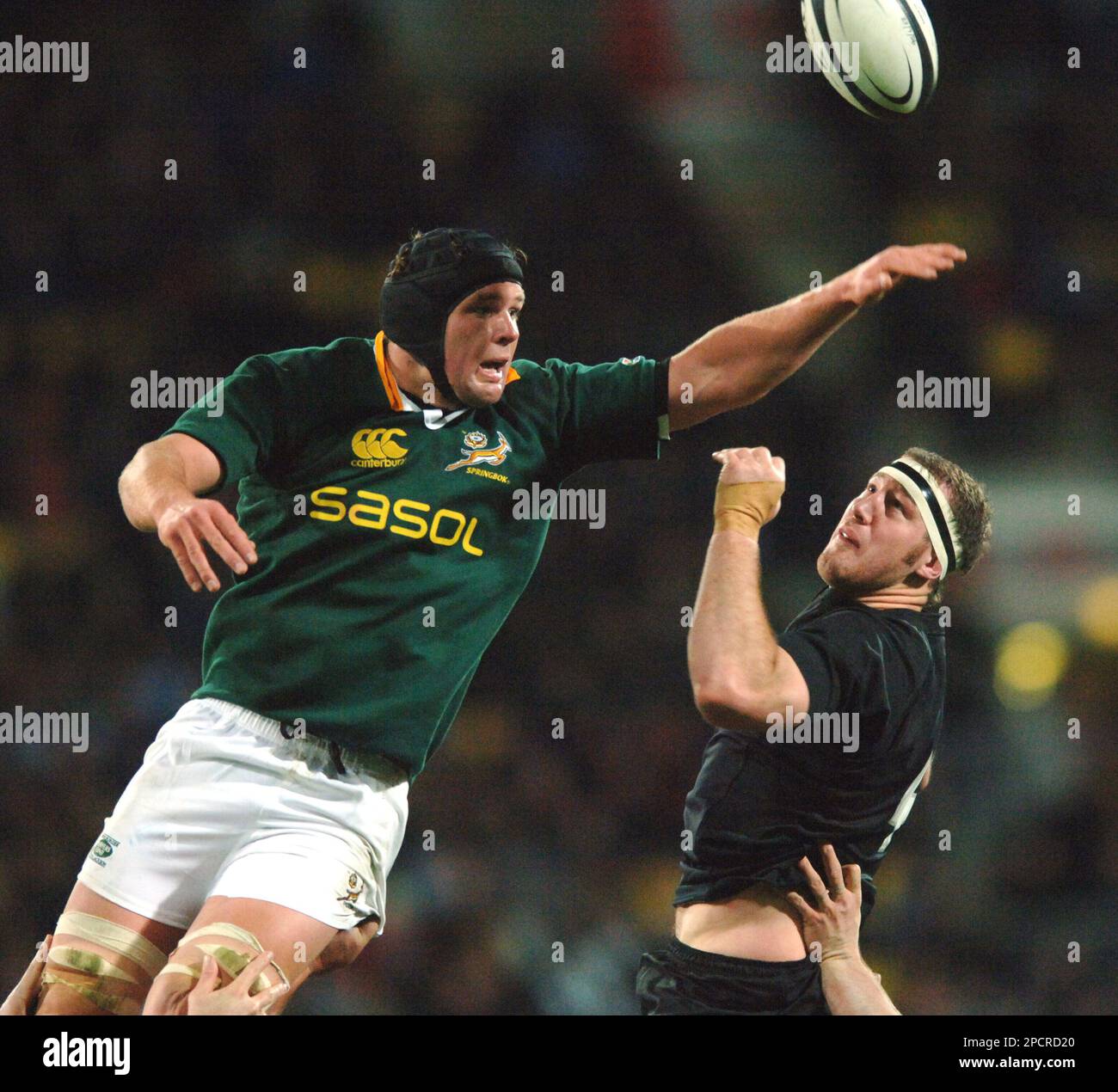 South Africa's Jacques Cronje, left, leaps over All Blacks Chris Jack ...