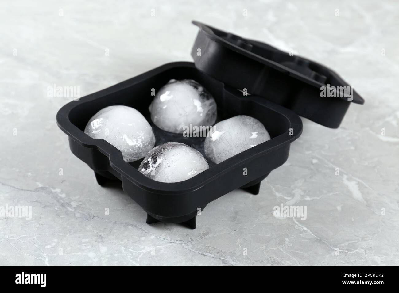 Frozen ice balls in mold on grey table Stock Photo - Alamy