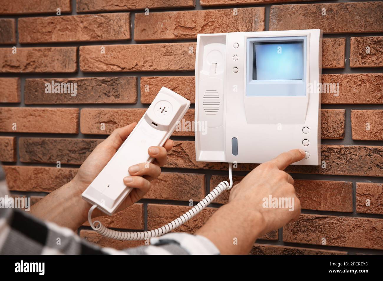 Man pressing button on intercom panel indoors, closeup Stock Photo - Alamy