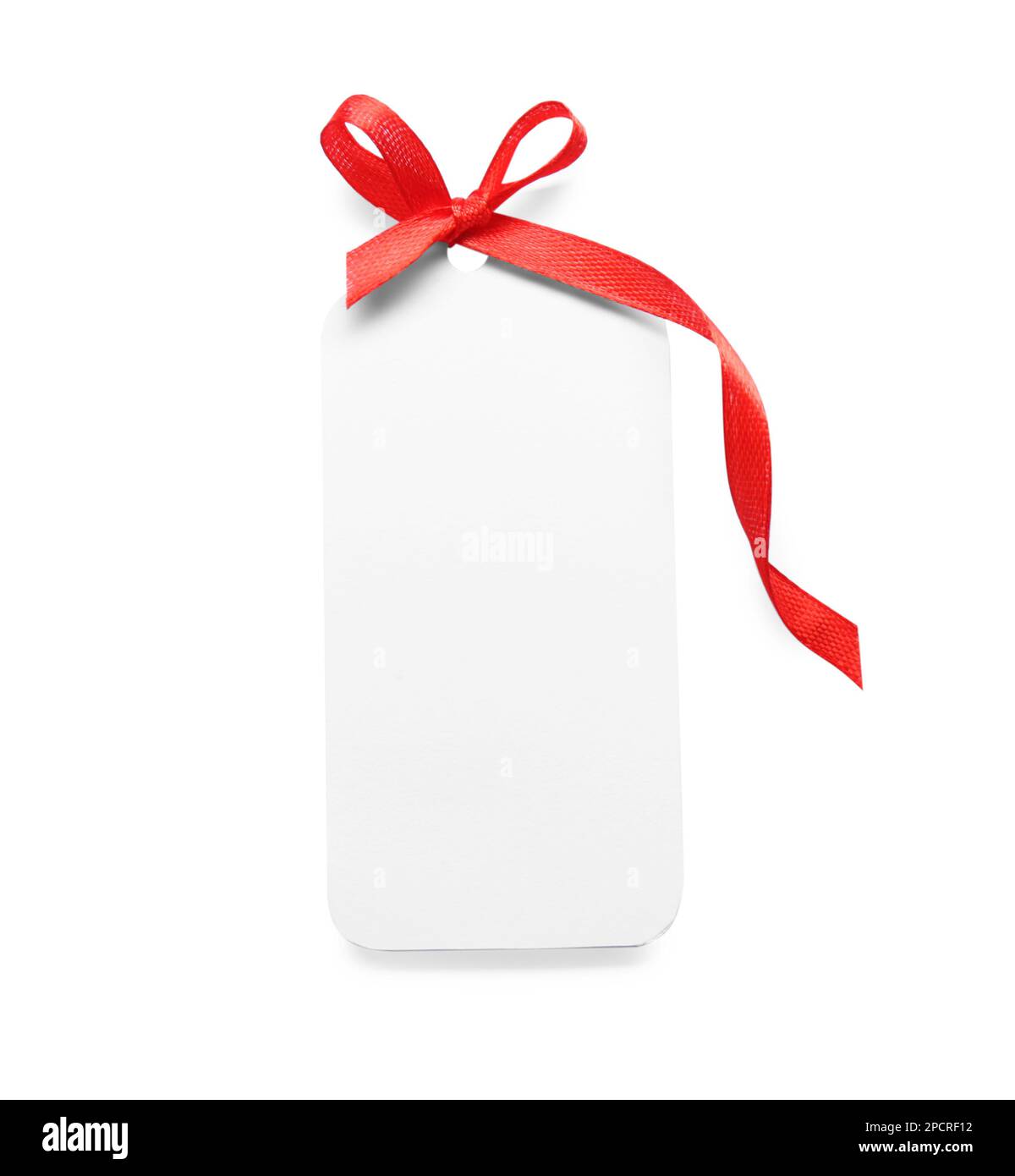 Blank gift tag with red satin ribbon on white background, top view ...