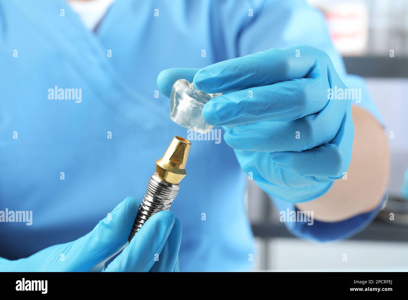 Dentist putting crown onto abutment of dental implant on blurred ...