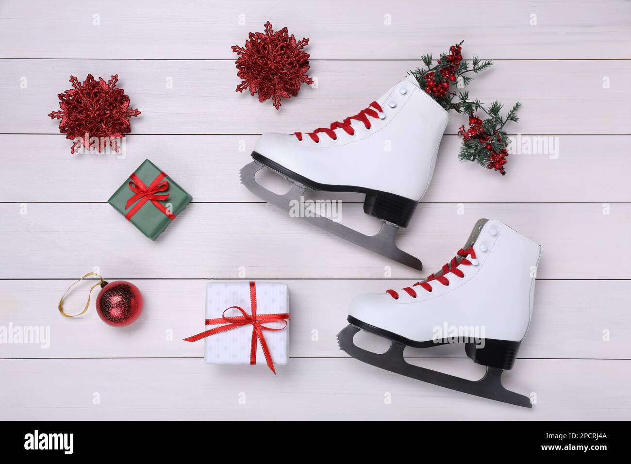 Pair of ice skates, Christmas decor and gift boxes on white wooden ...
