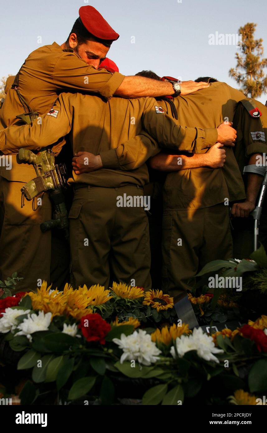 Israeli soldiers huddle together and grieve at the funeral for Yonatan ...