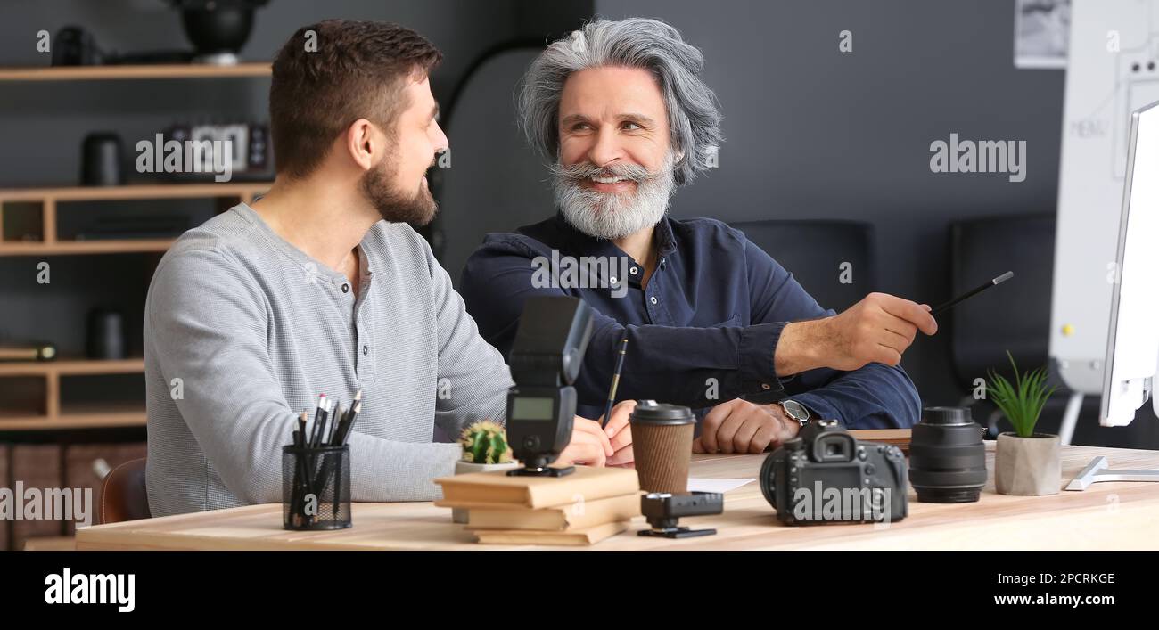 Mentor teaching young photographer in modern studio Stock Photo - Alamy