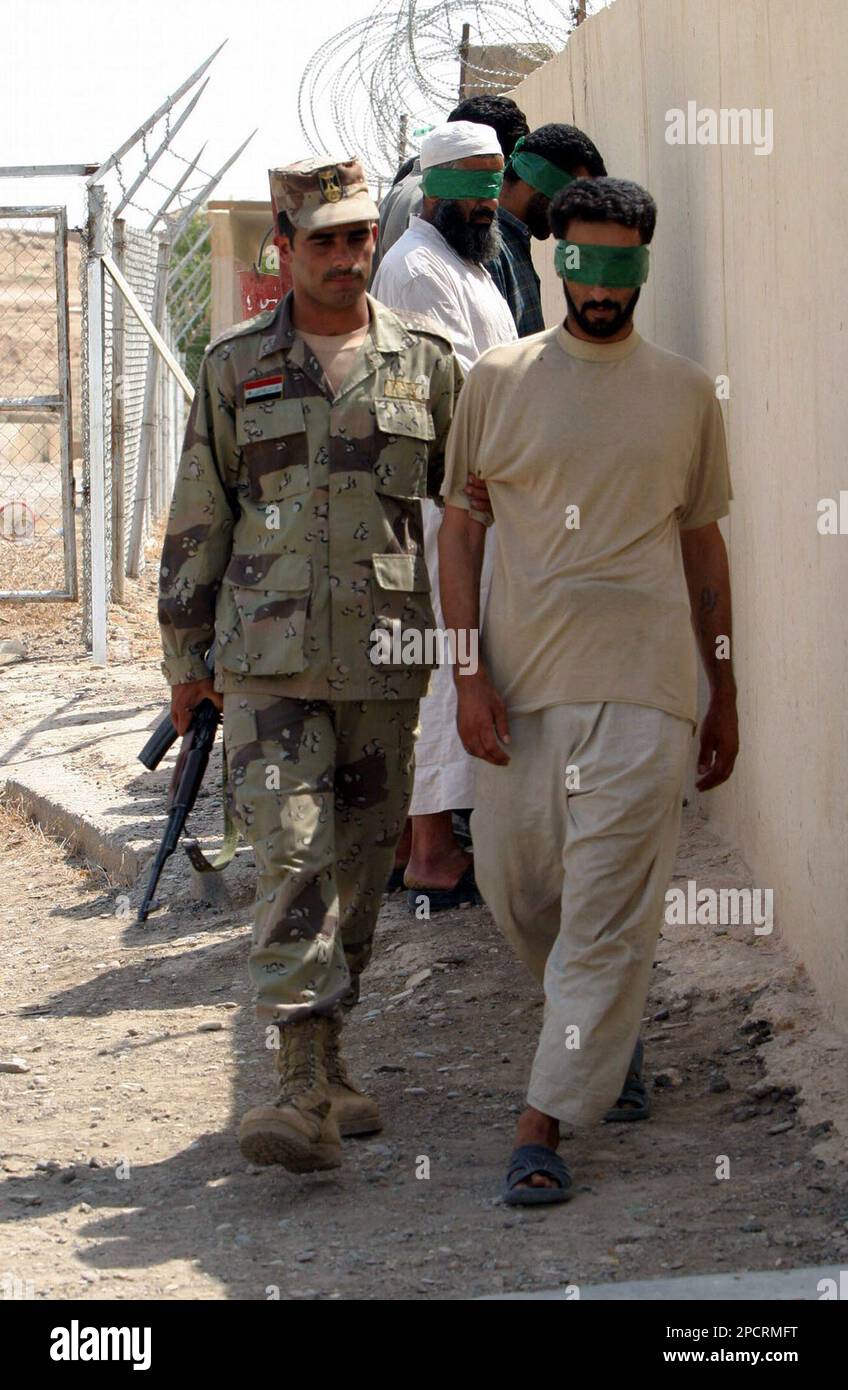 Iraqi troops escort blindfolded suspects arrested during a raid ...