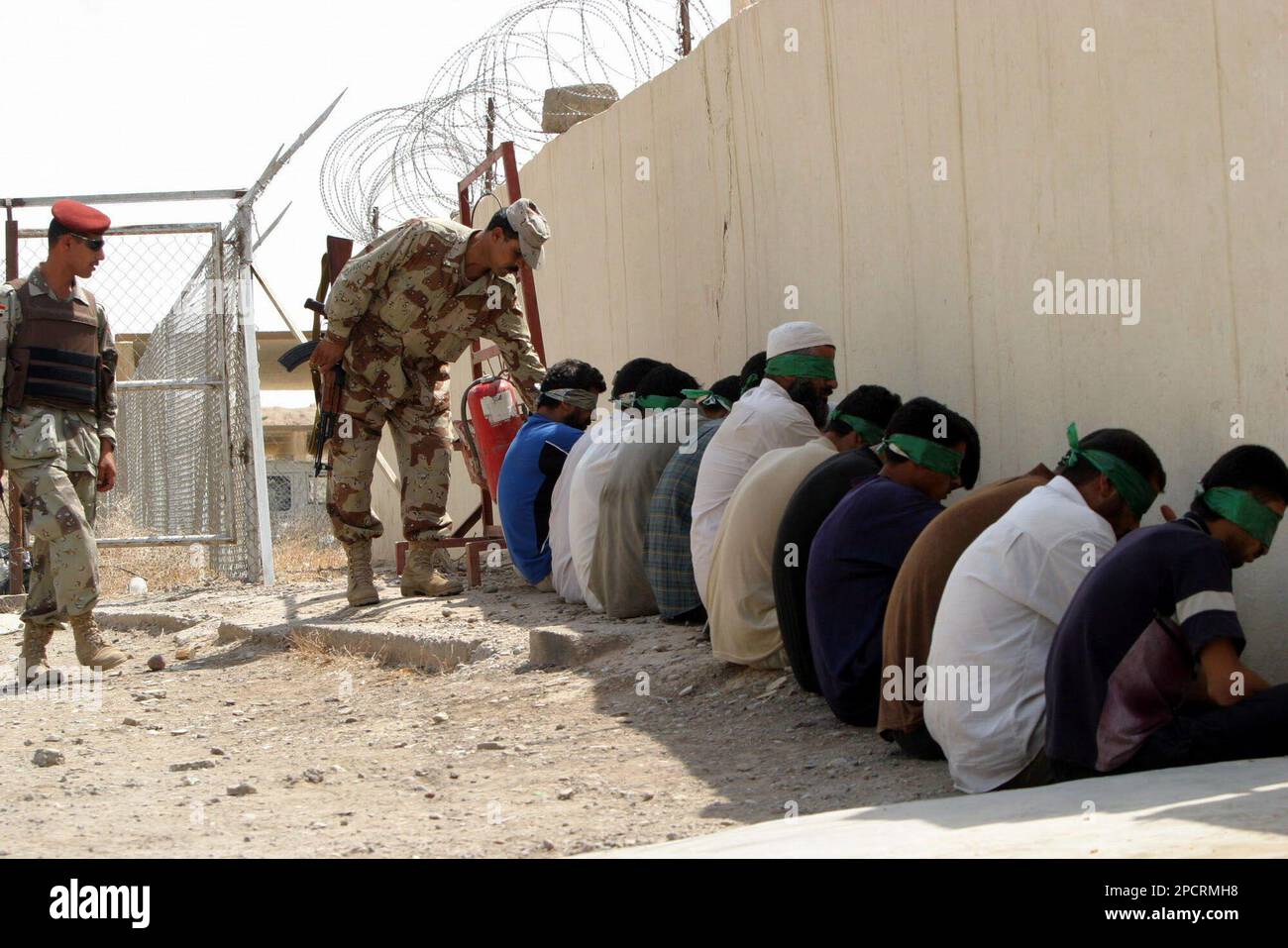 Iraqi troops line up blindfolded suspects arrested during a raid ...