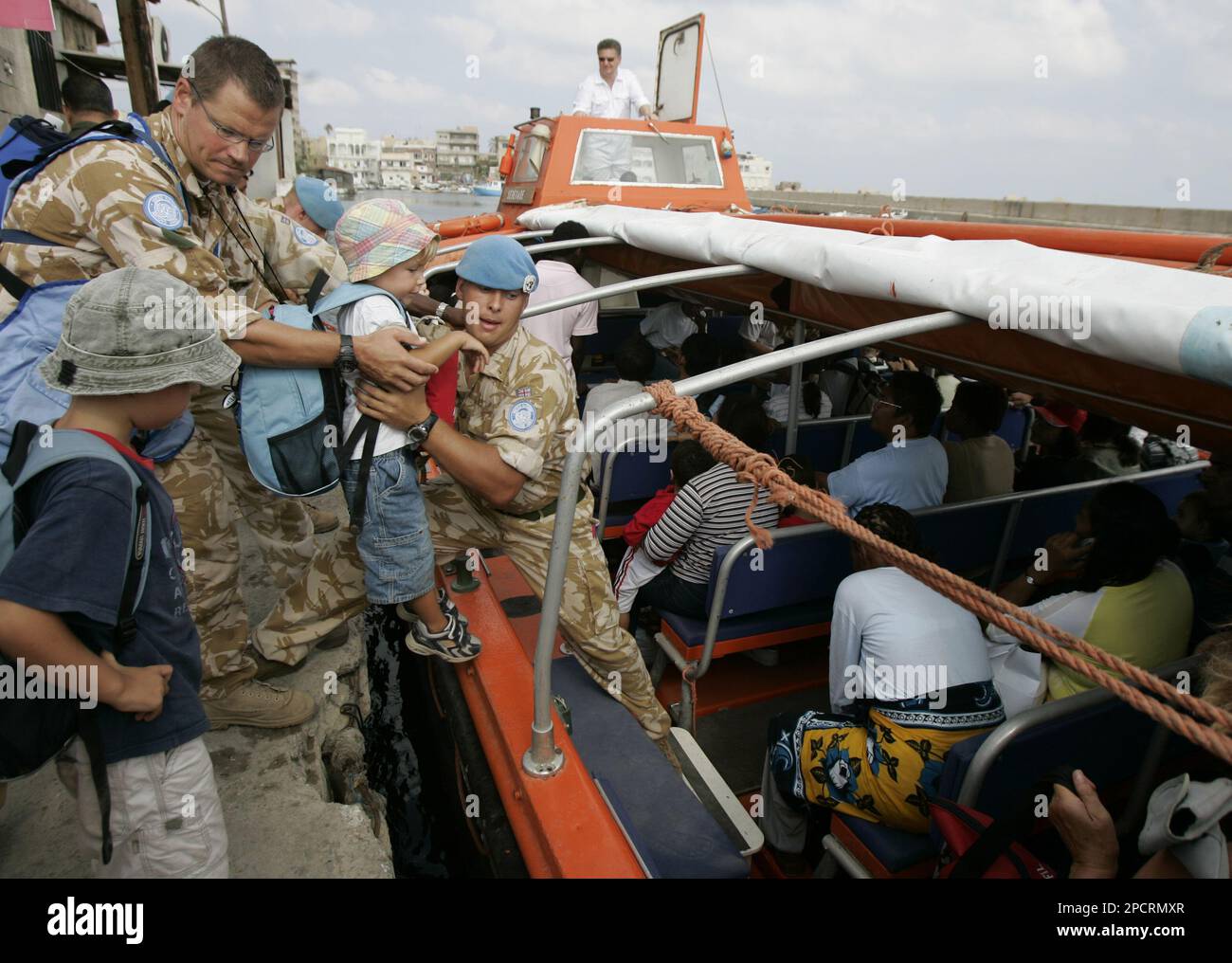 United Nations troops move a child onto a boat to be evacuated out of ...