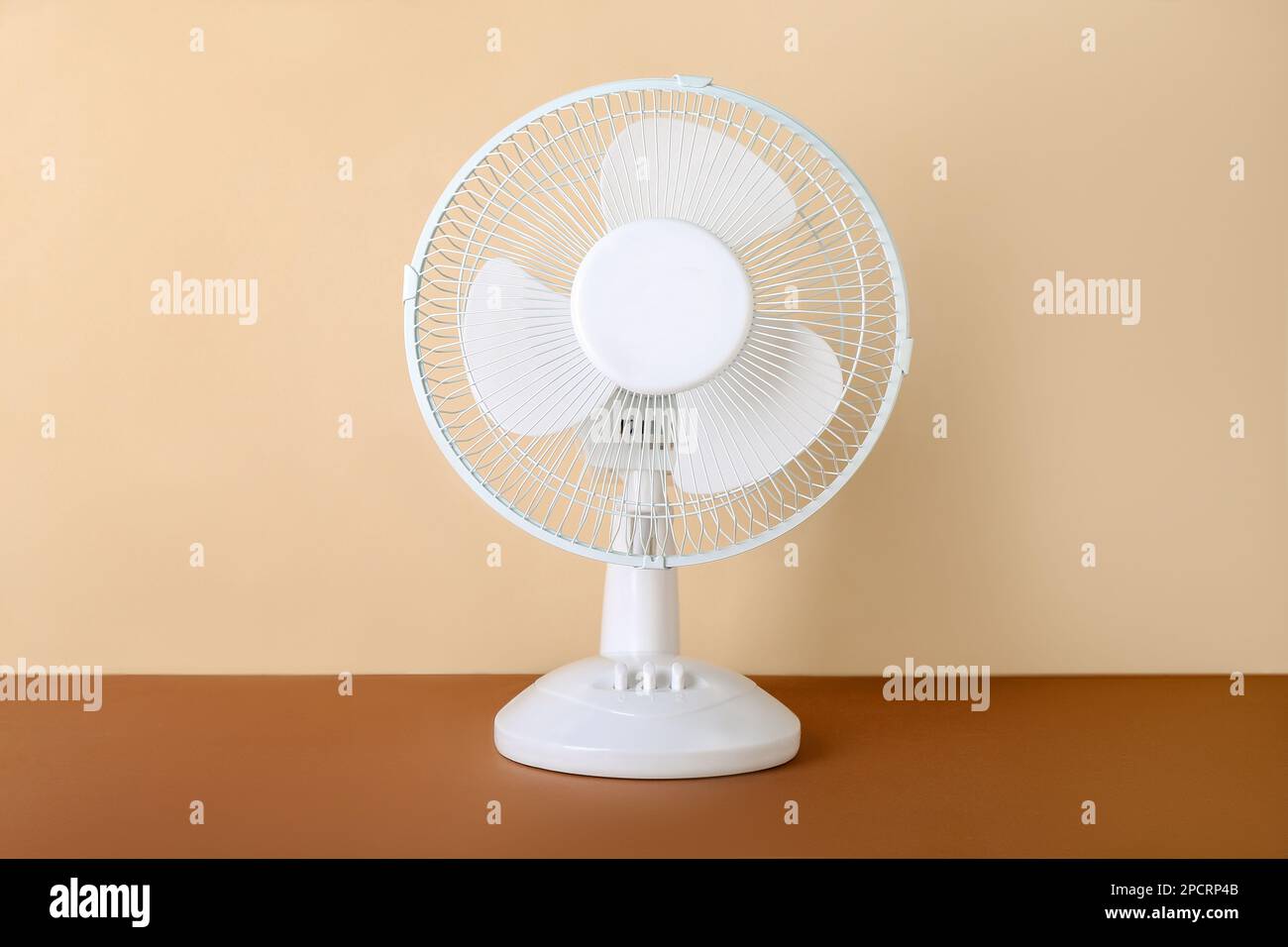 Electric fan on beige background Stock Photo - Alamy