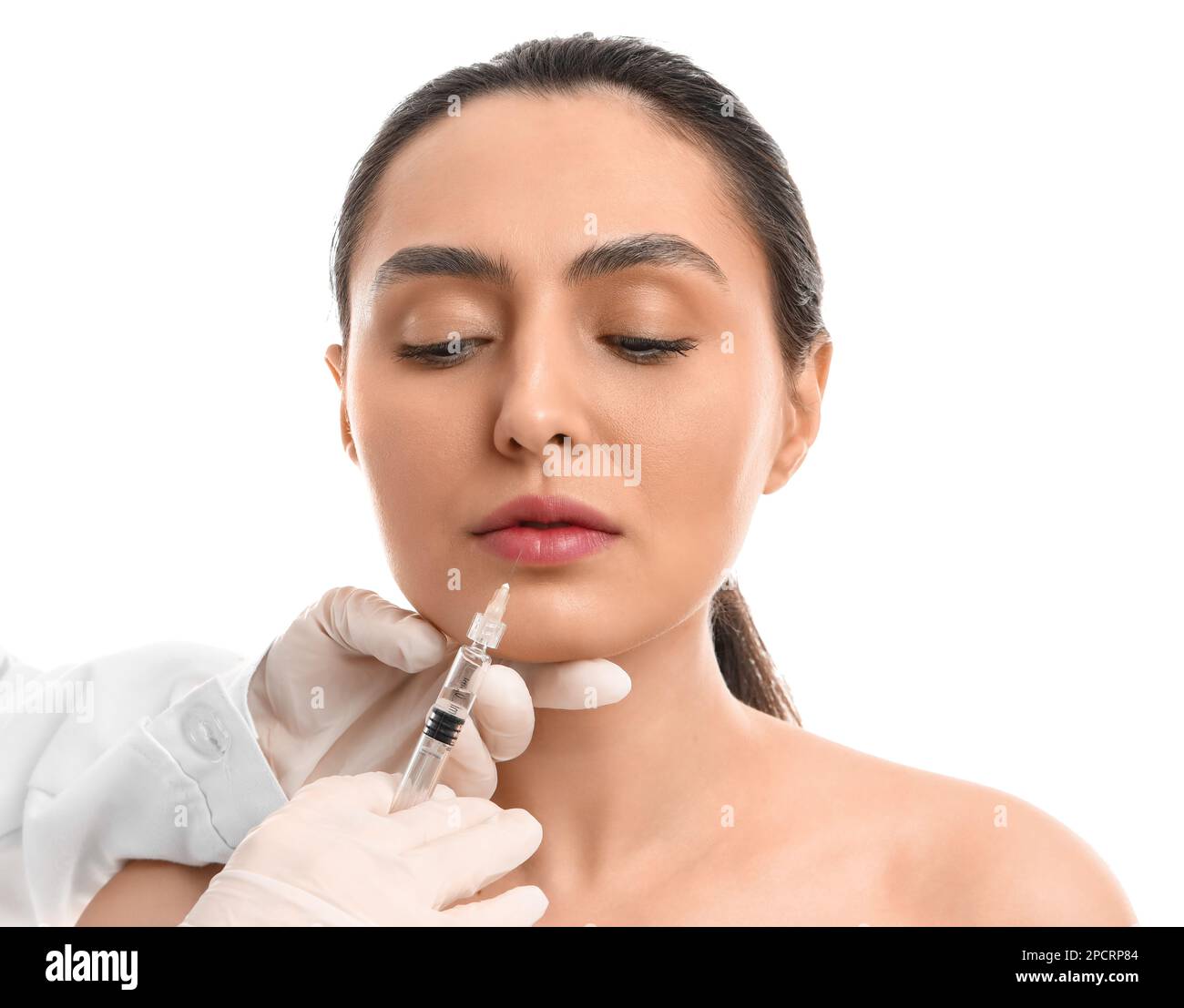 Young woman receiving filler injection in face against white background ...
