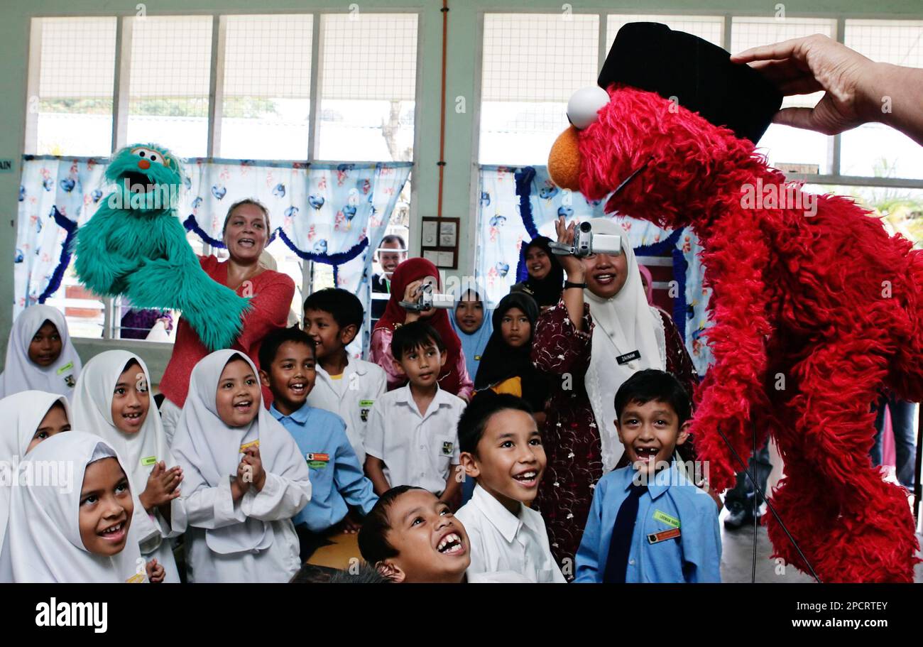 Sesame Street muppet Elmo, right, wears a Muslim hat and Rosita, behind ...