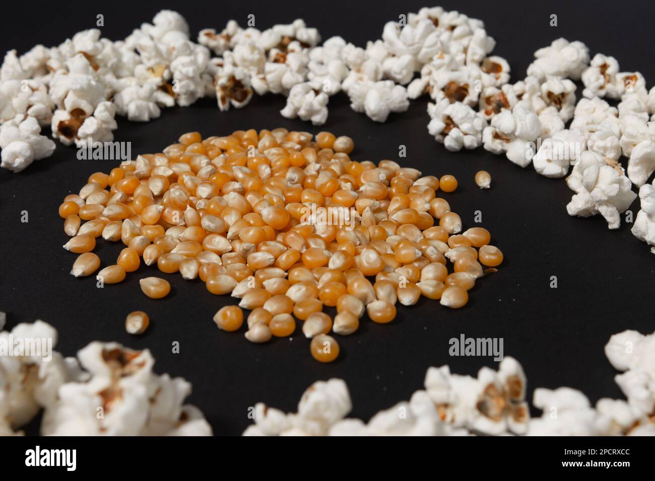 A pile of corn kernels in the middle of a ready-made popcorn circle ...