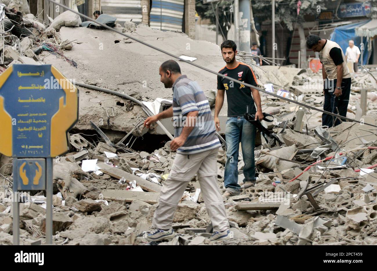 A Hezbollah fighter, center-right, walks through a destroyed area of ...