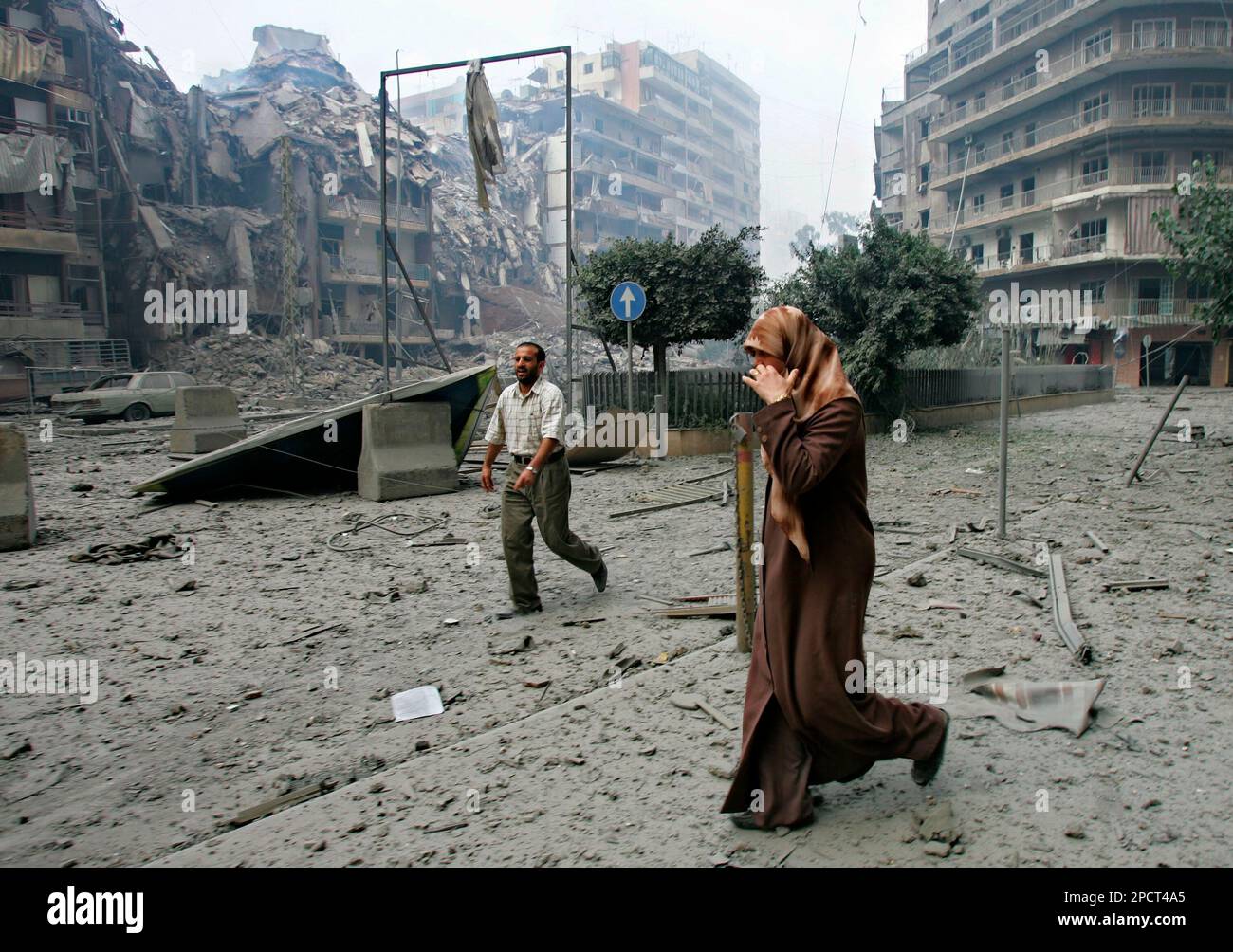 Lebanese citizens, who return to check their houses, walk next to ...