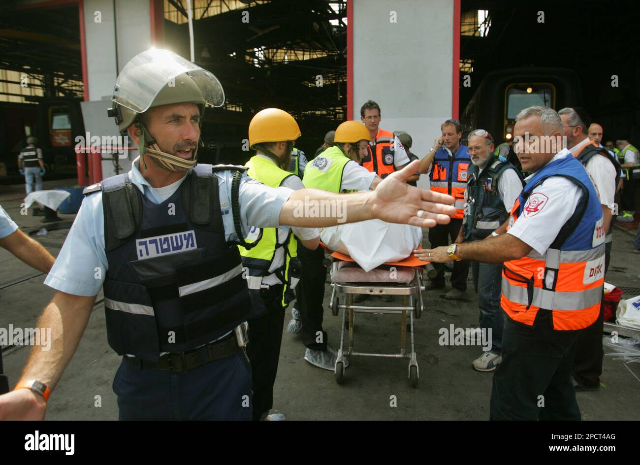 Police and medics wheel a dead Israeli from the site of a rocket attack ...