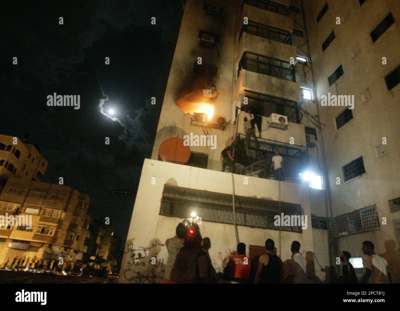 Palestinian firefighters climb the outside of the offices for National ...