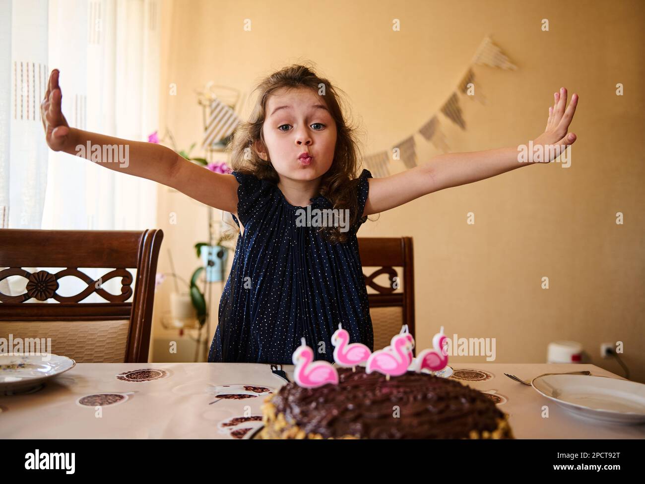 Lovely little child girl blowing air kiss, looking at camera, sitting ...
