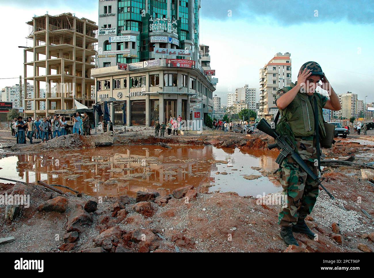 A Lebanese soldier stands next to a crater following Israeli airstrikes ...