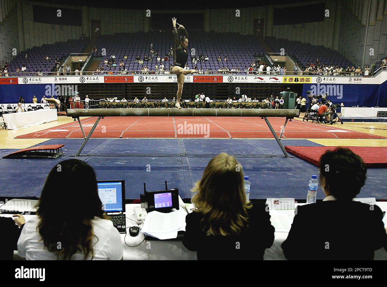 Li Ya of China performs in front of judges during the women's beam ...