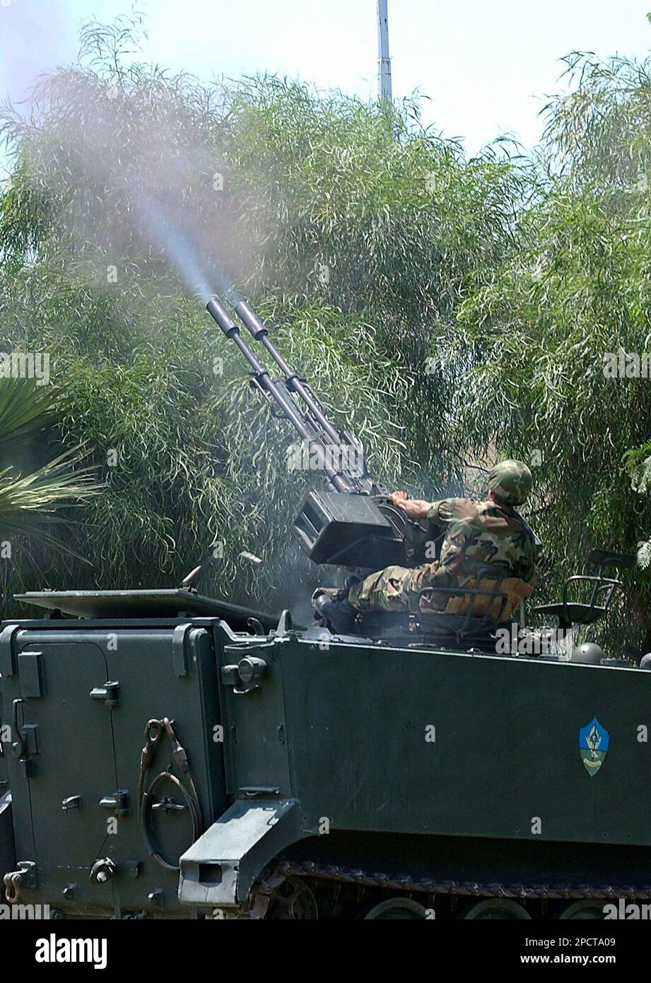 A Lebanese soldier, sitting behind an anti-aircraft gun, fires at ...