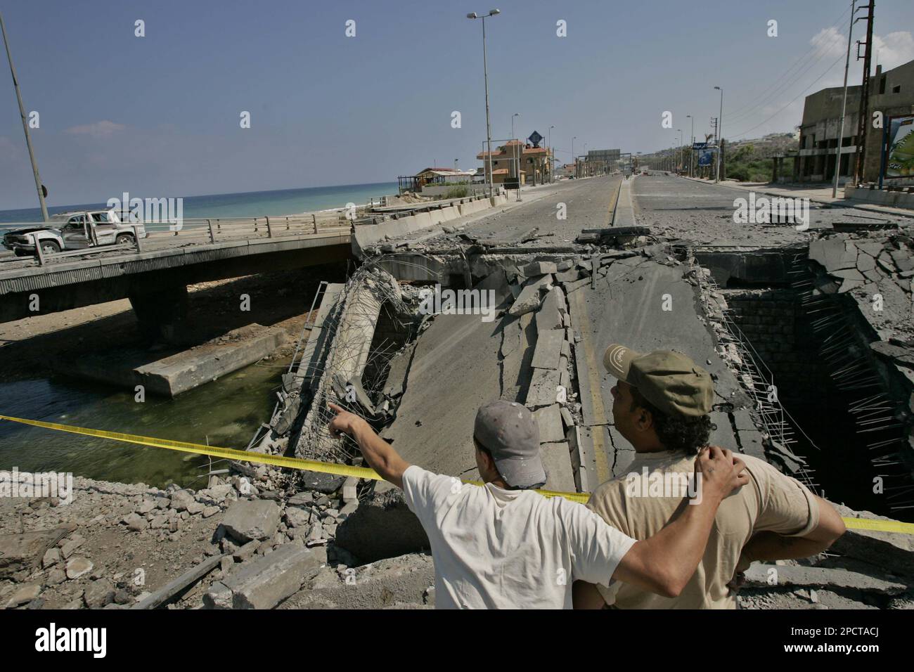 Lebanese youths inspect the damage at a bridge over the Awali River ...