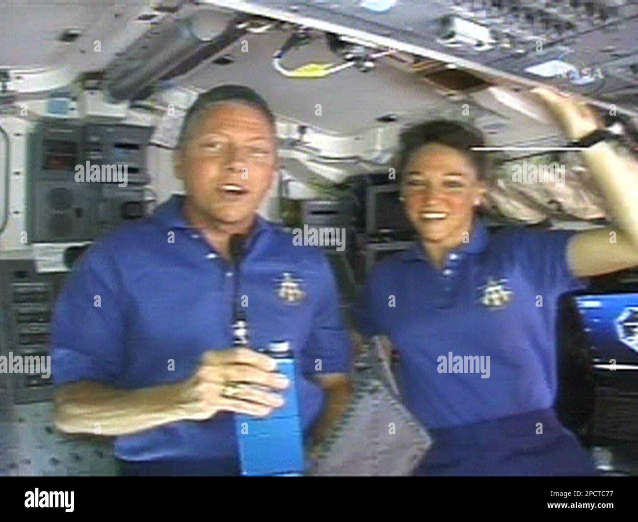 In this image made from NASA TV, astronaut Mike Fossum, left, and ...