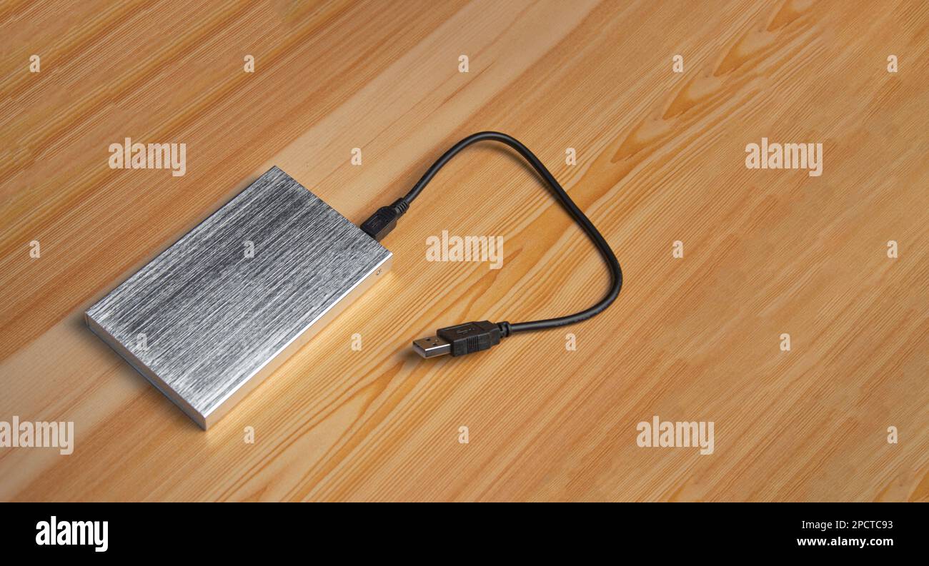 Top view of silver external hard drive laying on wooden background ...