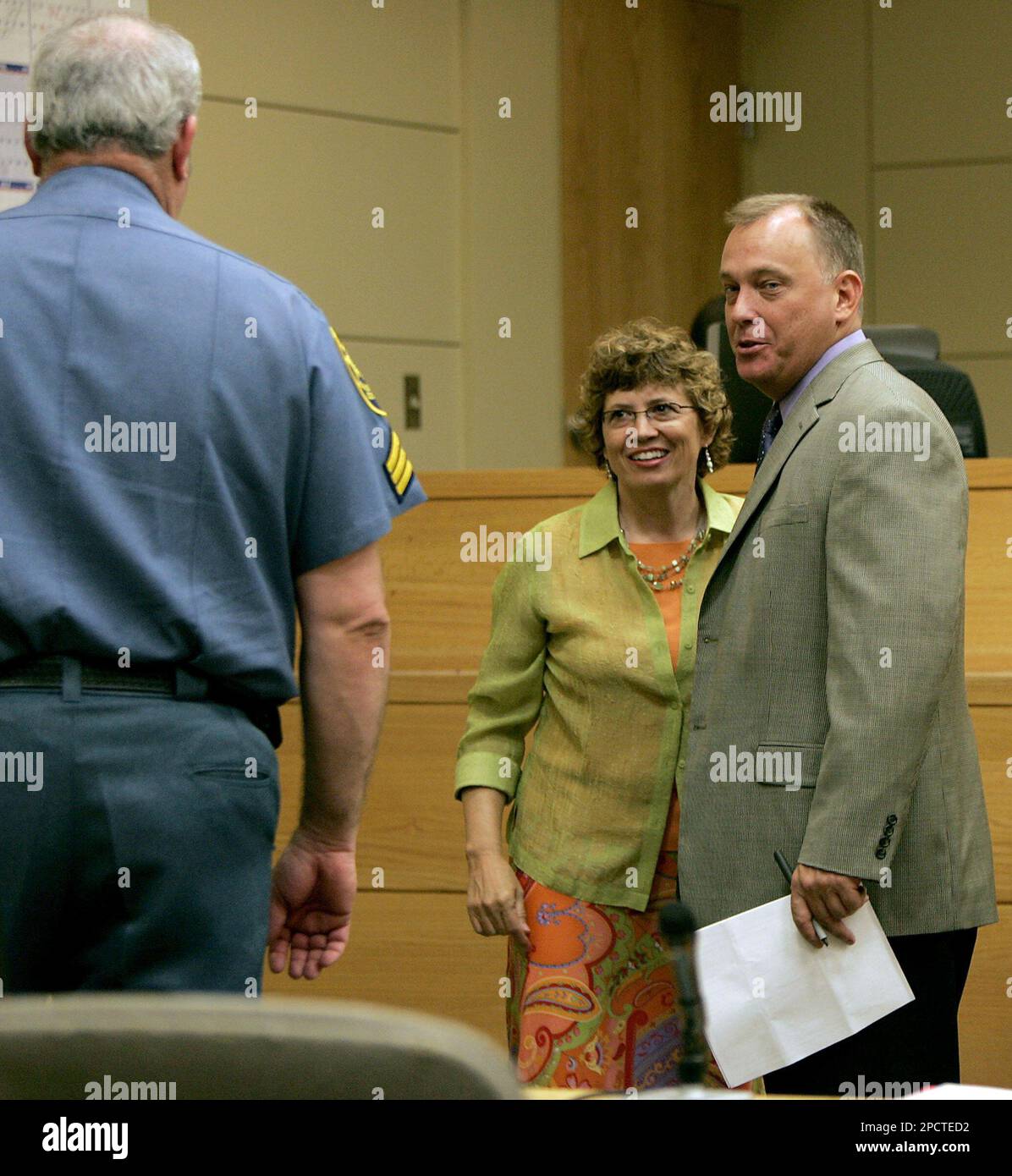 Toby Young, center, stands with her lawyer Jim Yoakum before being led ...