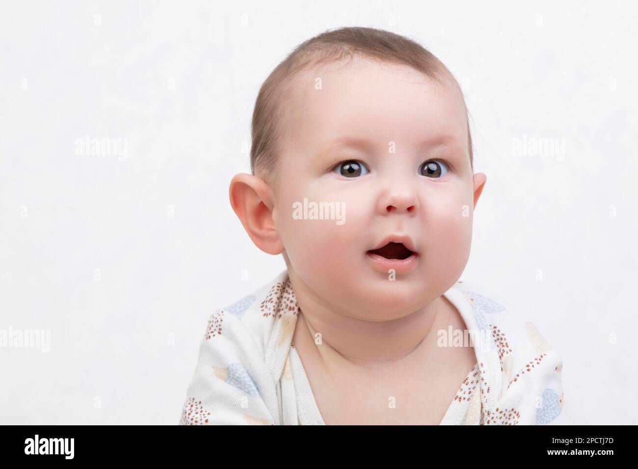 Six month old baby on a white background. Happy boy mid-range ...