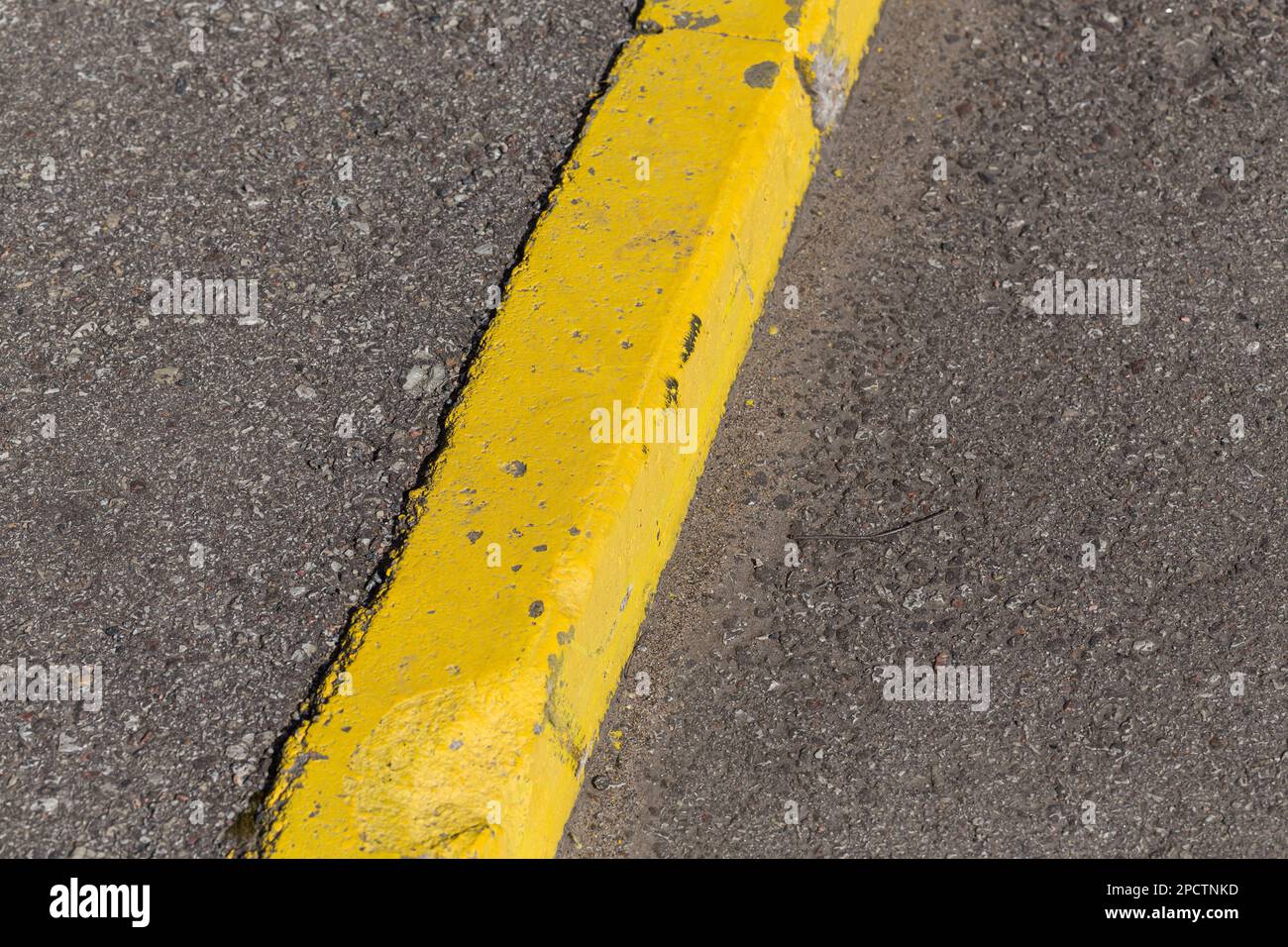 Yellow curb stone border and asphalt road Stock Photo - Alamy