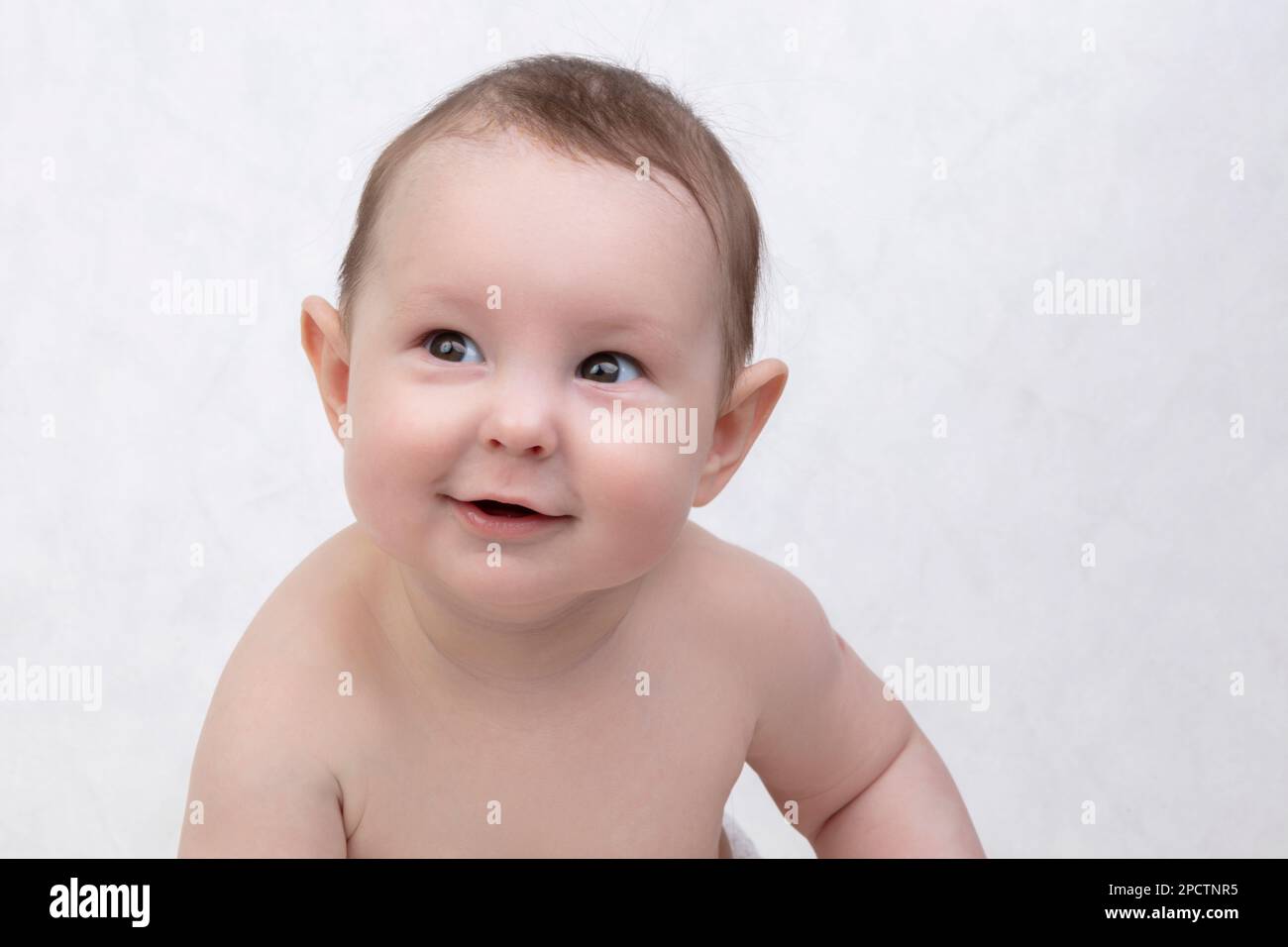 Six month old baby on a white background. Happy boy mid-range ...