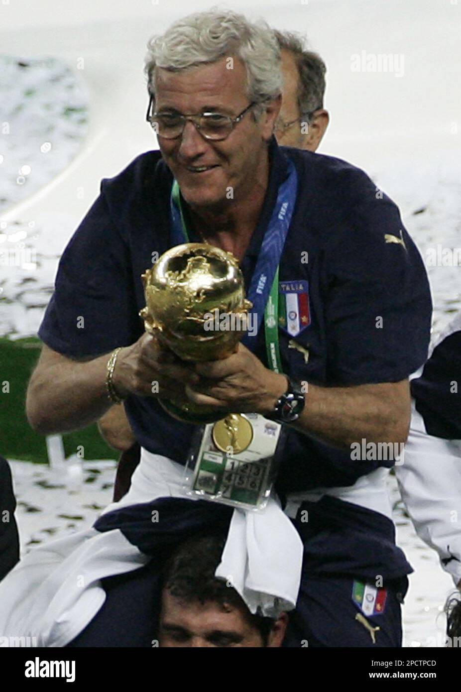 Italy's coach Marcello Lippi holds the World Cup trophy at the end of ...