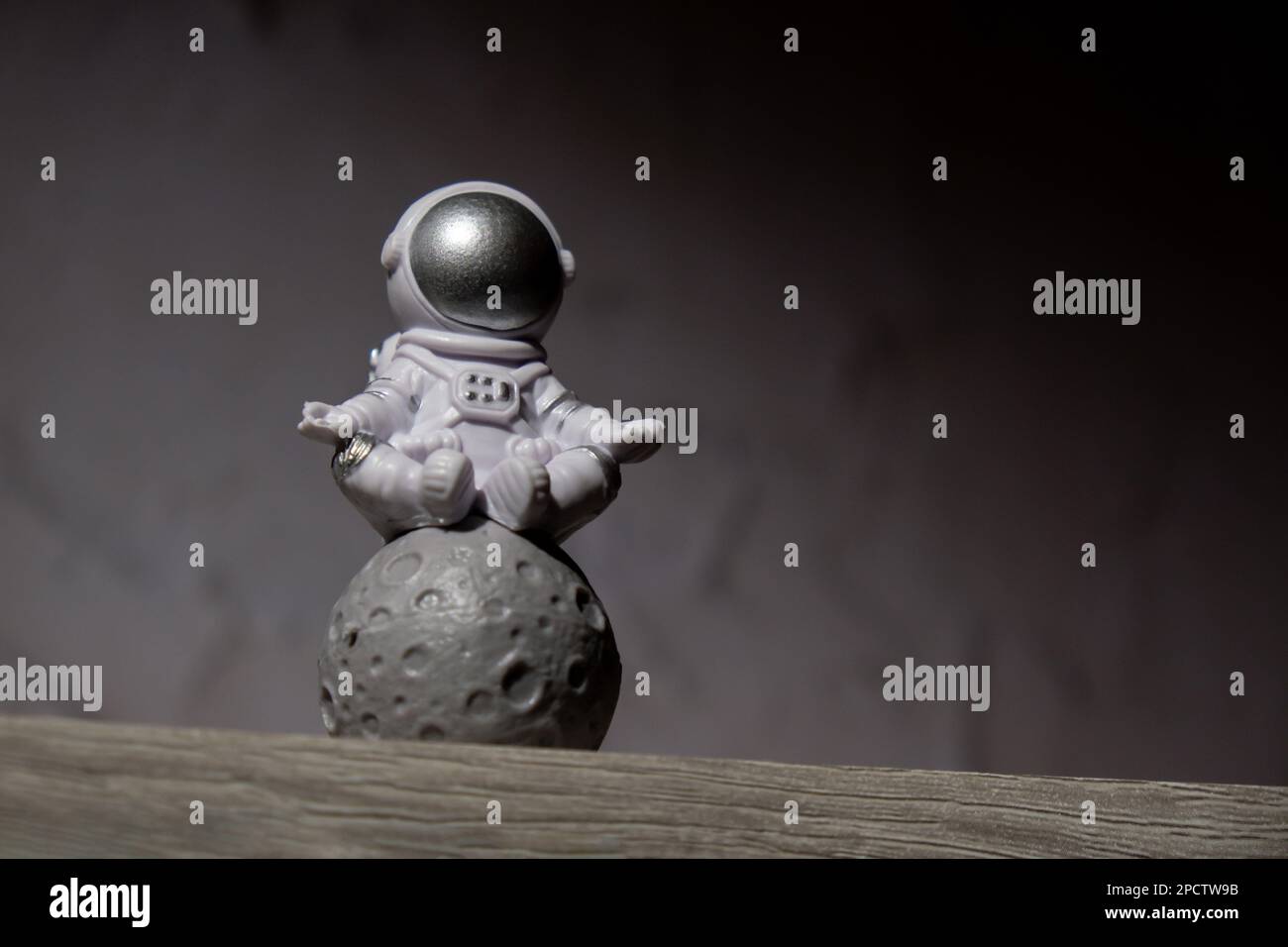 Plastic toy figure astronaut on moon concrete background Copy space ...
